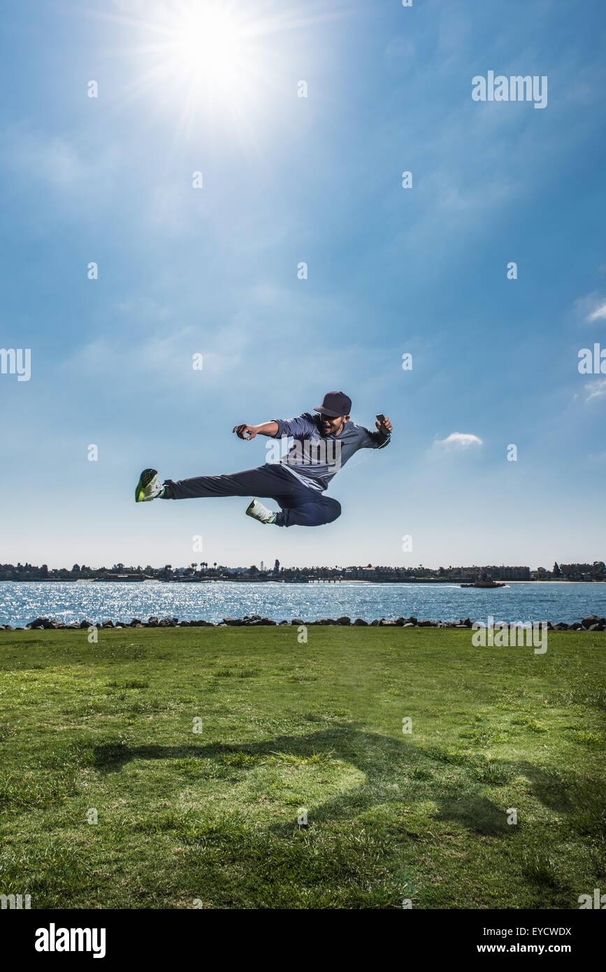 Fit mid adult man poised jumping mid air at coast Stock Photo - Alamy