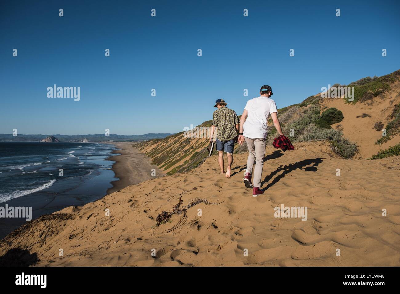 Two young men walking along sand hi-res stock photography and images ...