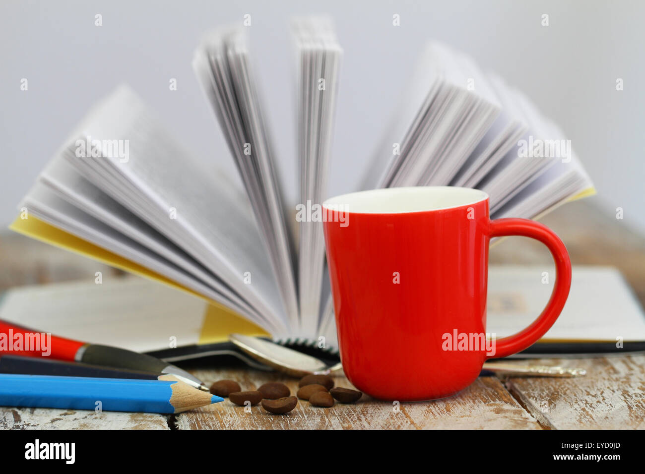 Mug of coffee with open book in the background Stock Photo - Alamy