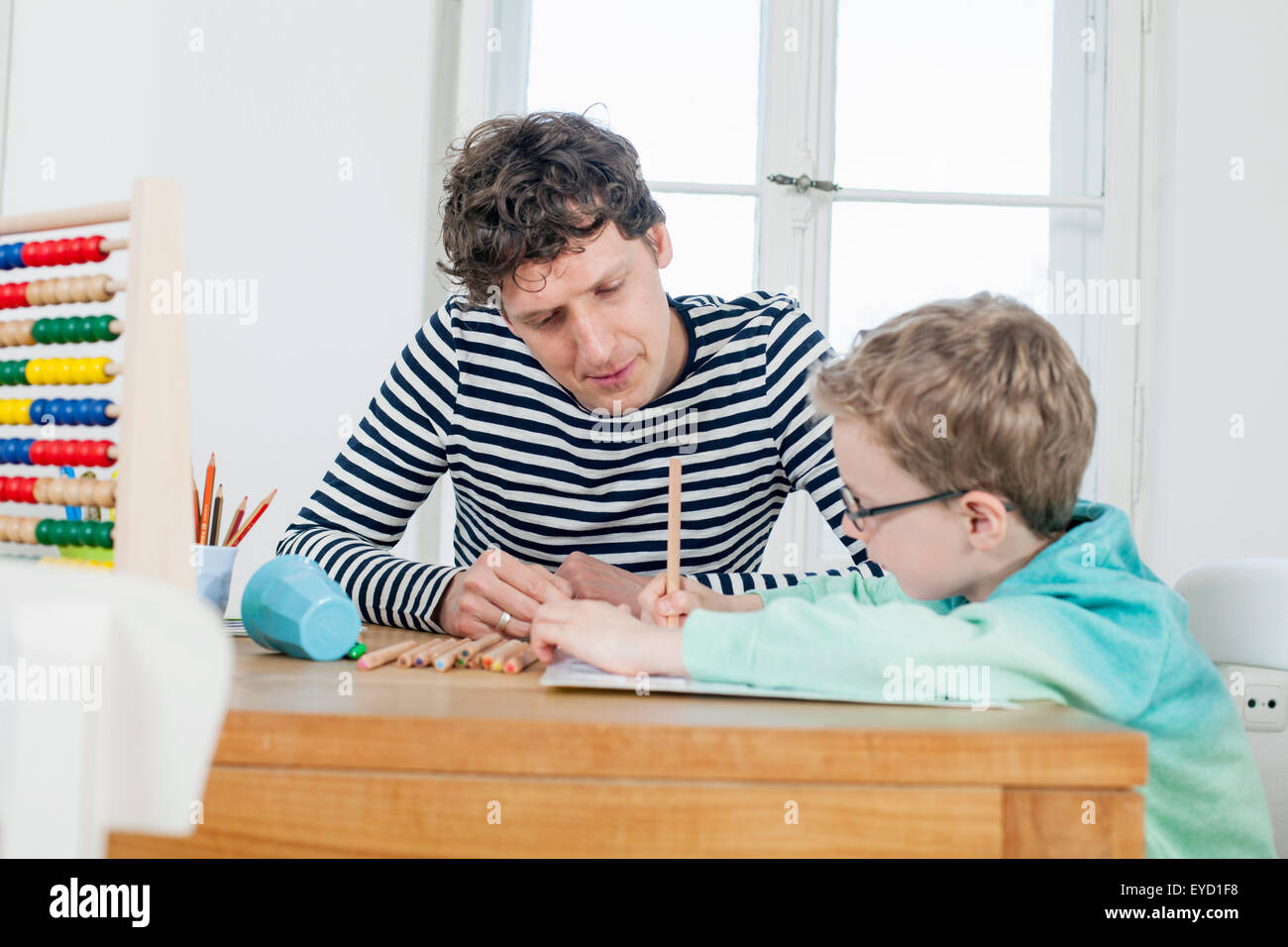 Father helps son learning to write Stock Photo - Alamy