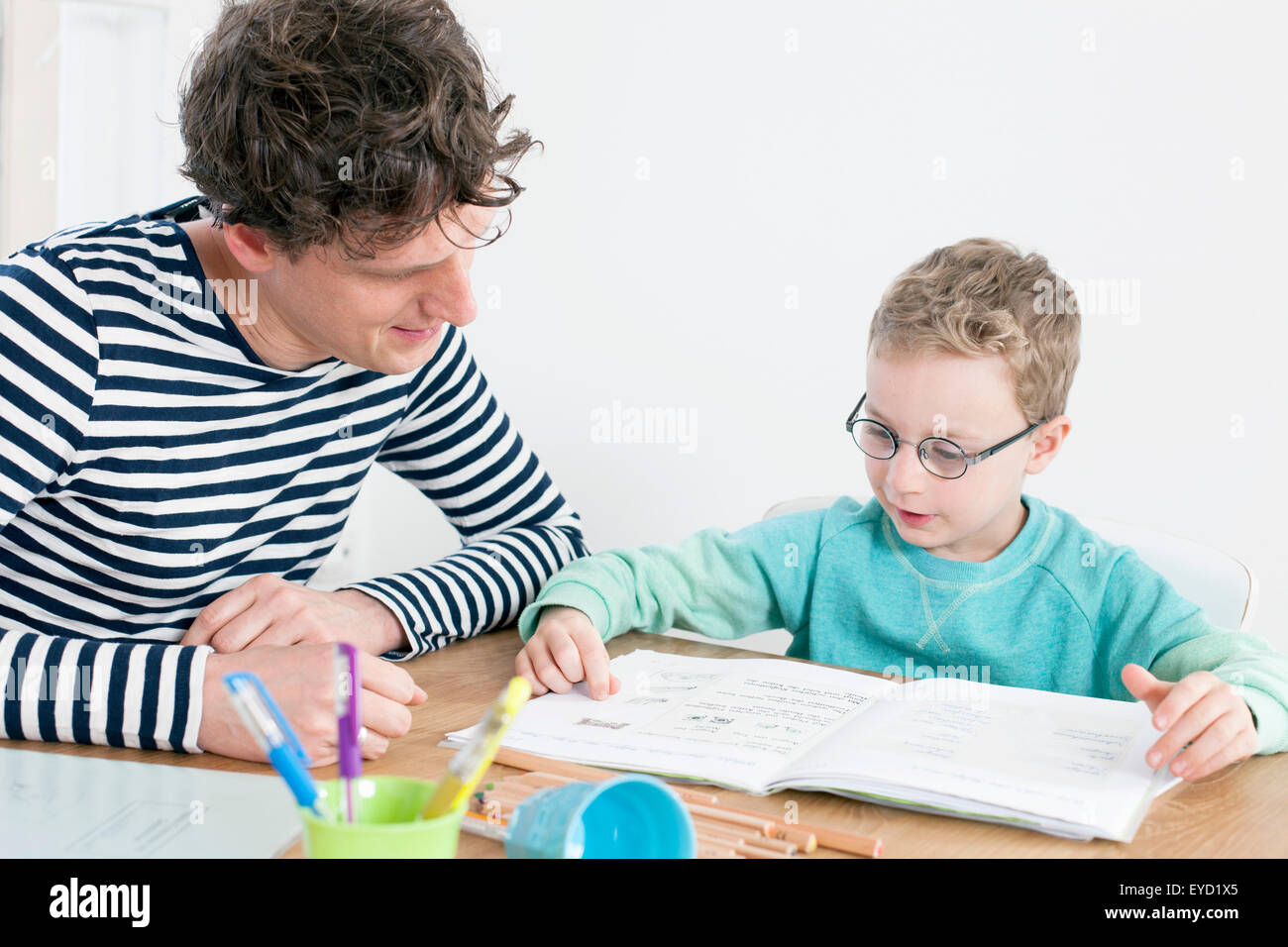 Father helps son learning to read Stock Photo - Alamy