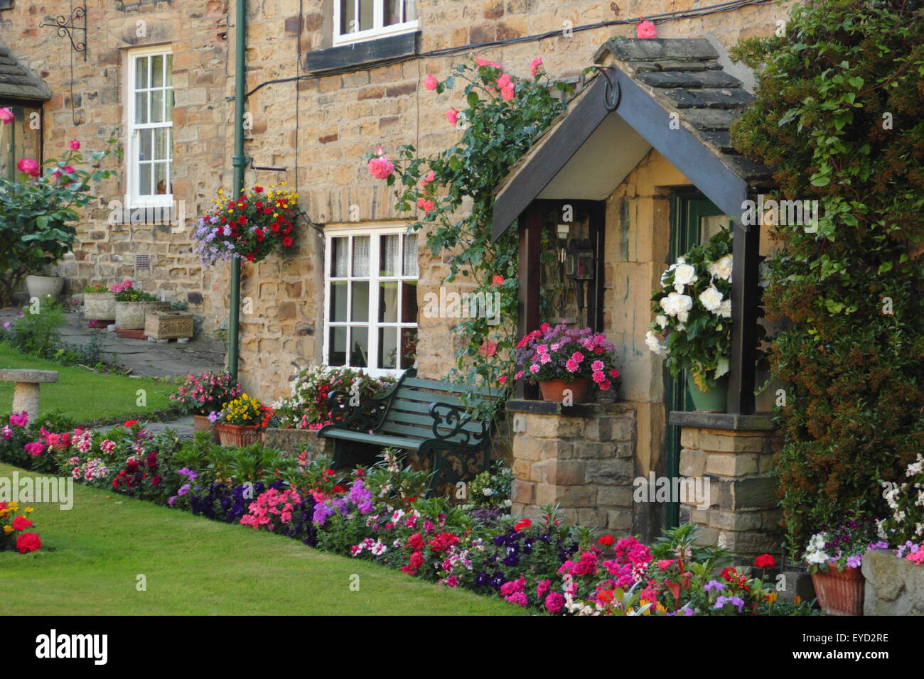 Traditional British stone-built cottages with pristine garden borders ...