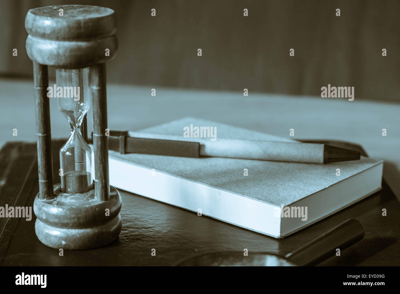 Hourglass on the book with black and white background Stock Photo - Alamy