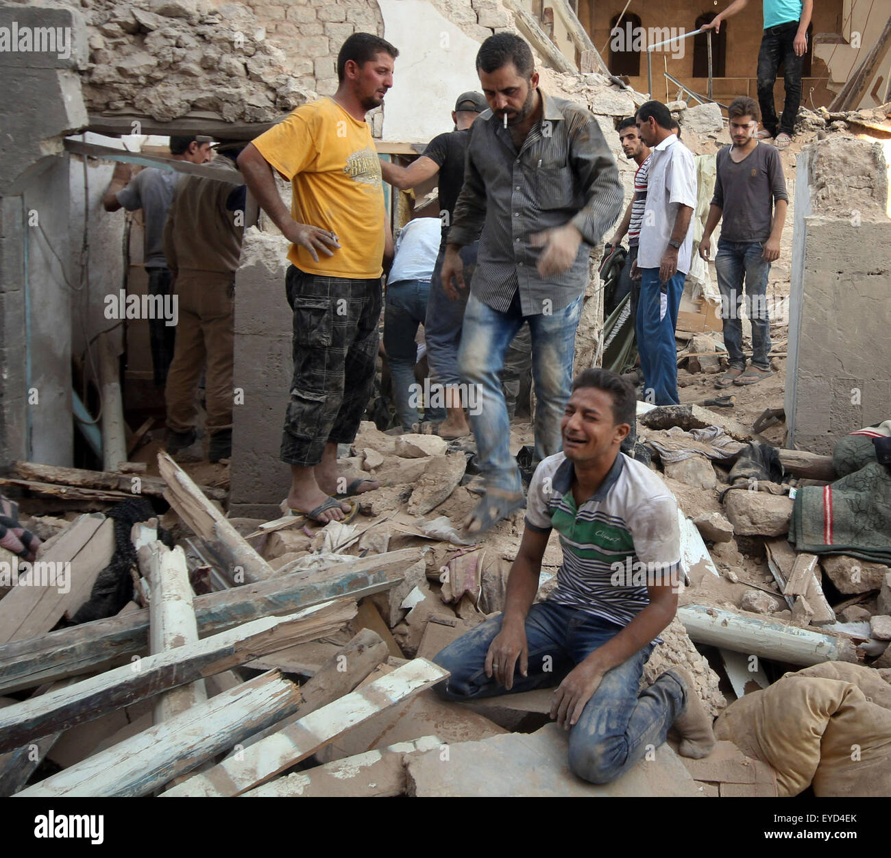 Aleppo, Syria. 27th July, 2015. A Syrian man cries as he sits on the ...
