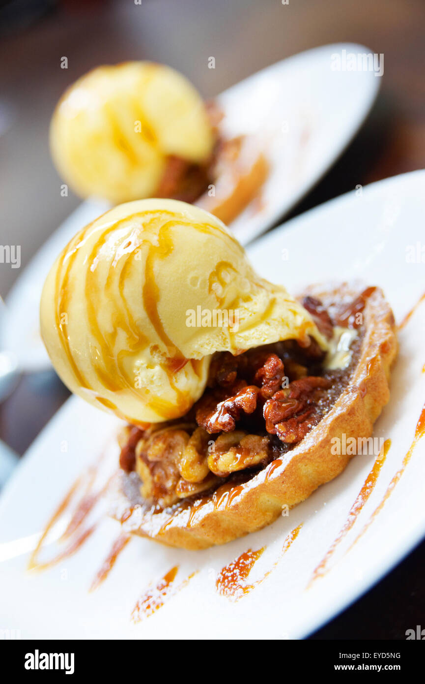 Toffee walnut tarts with vanilla ice cream and toffee sauce drizzled ...
