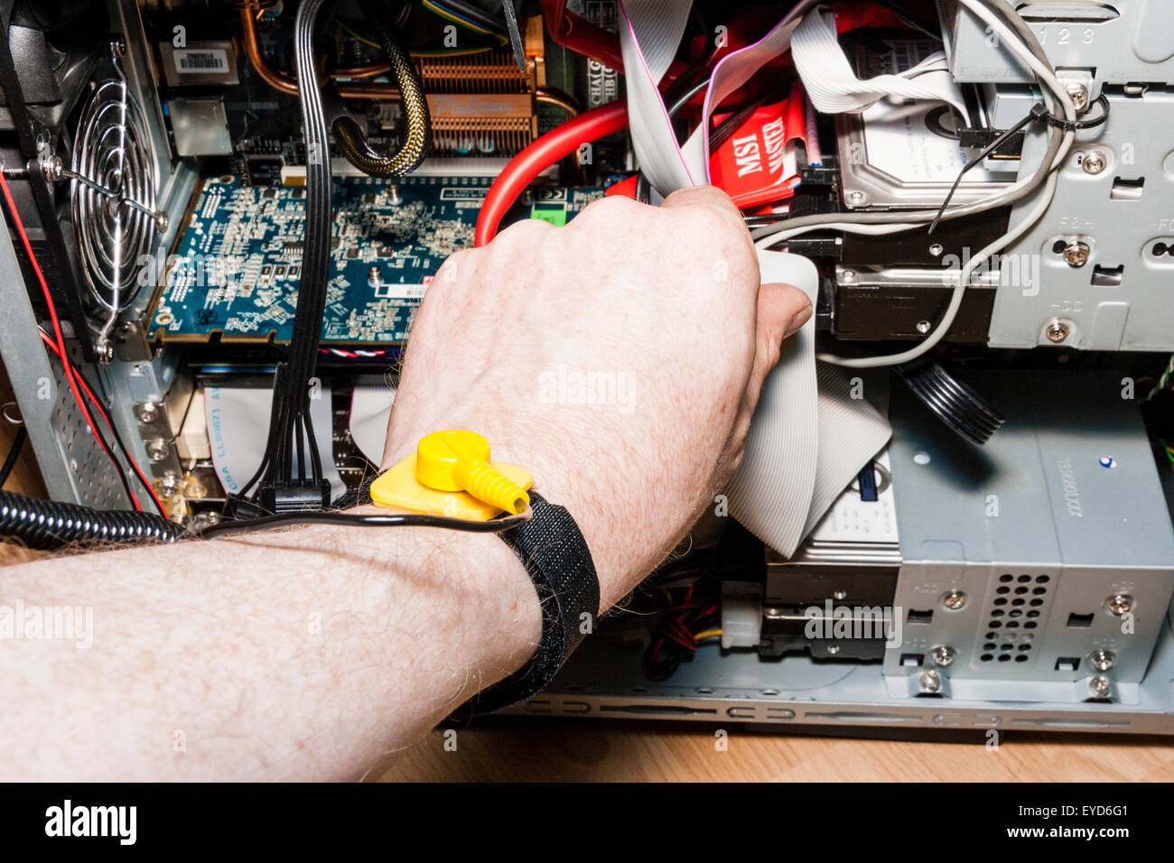 Hand with yellow static strap connected, reaching into the inside of a ...
