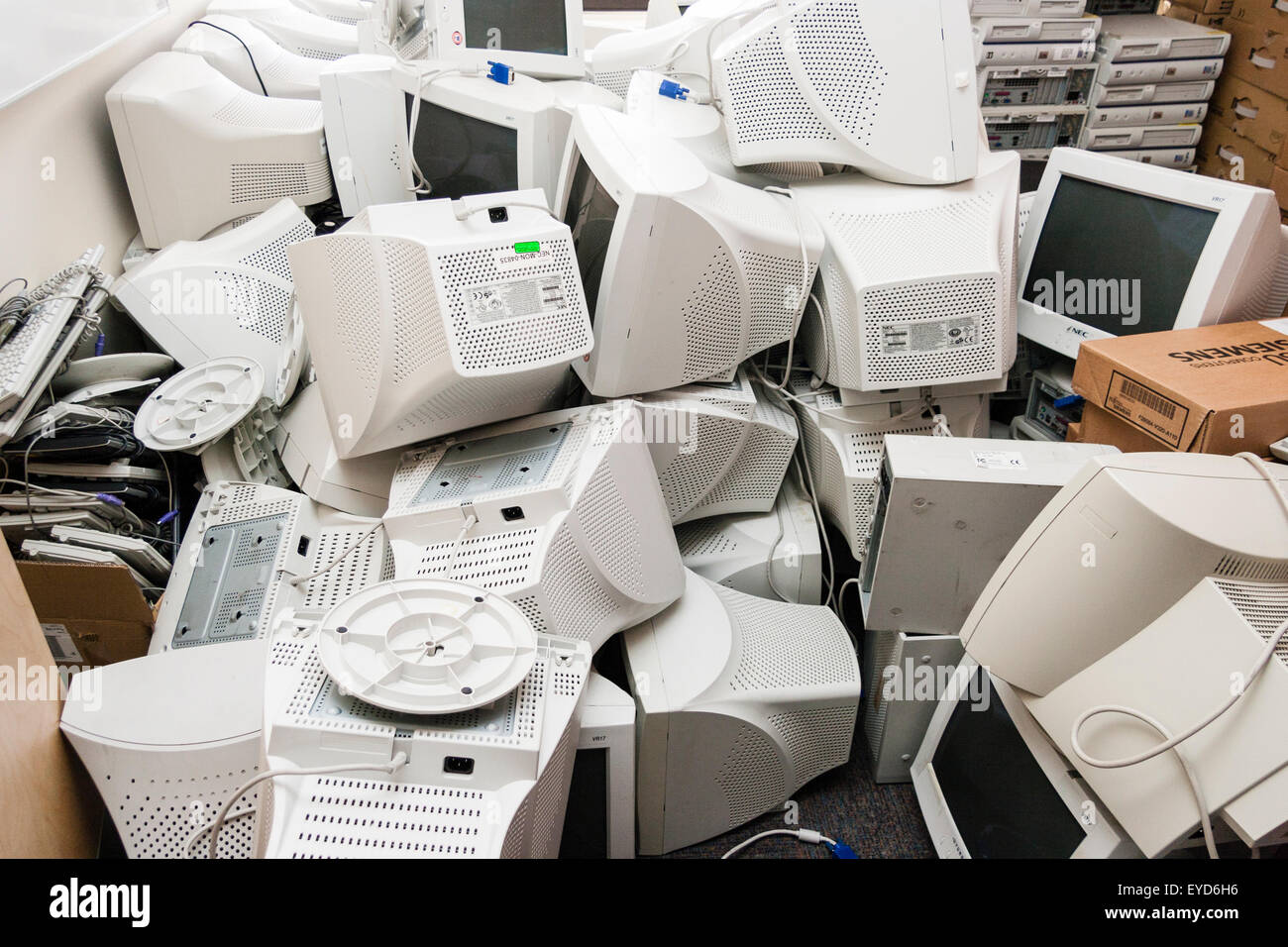 Junked computers stored in room. Piles of stacked white obsolete CRT ...