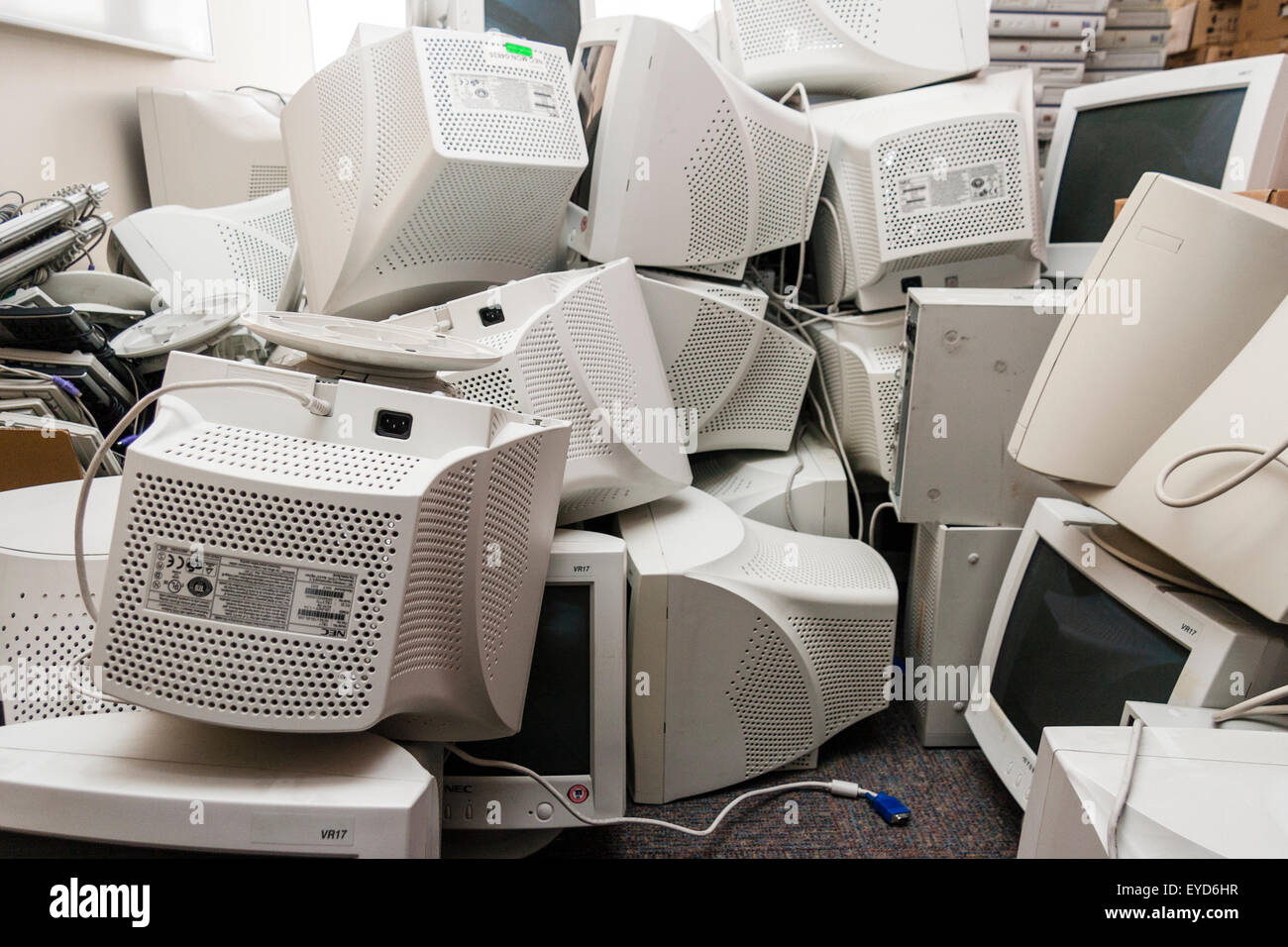 Junked computers stored in room. Piles of stacked white obsolete CRT ...