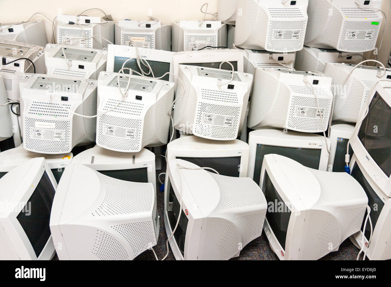 Junked computers stored in room. Piles of stacked white obsolete CRT ...