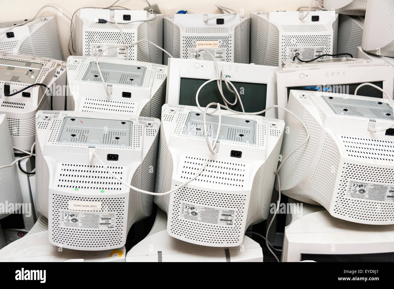 Junked computers stored in room. Piles of stacked white obsolete CRT ...