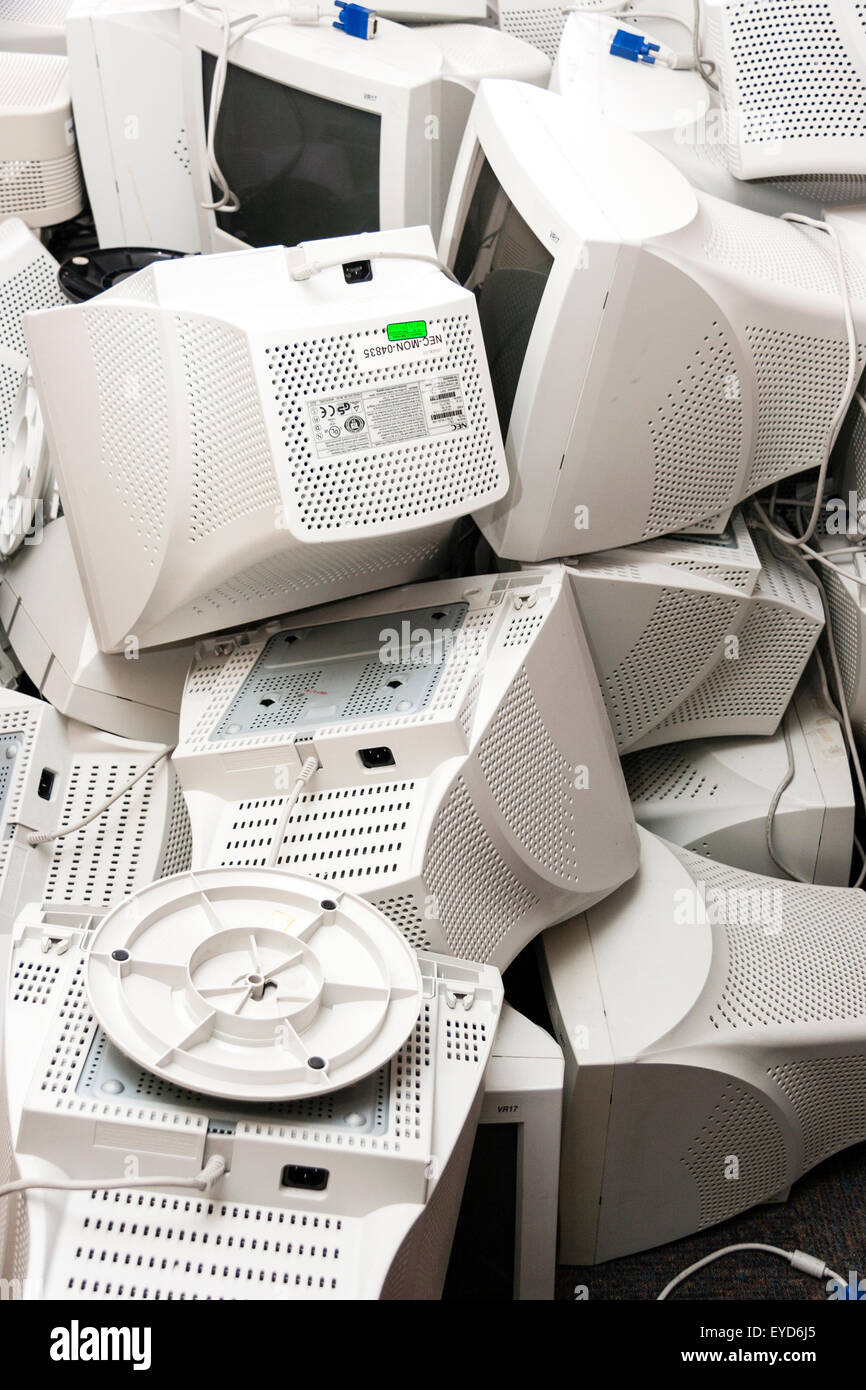 Junked computers stored in room. Piles of stacked white obsolete CRT ...