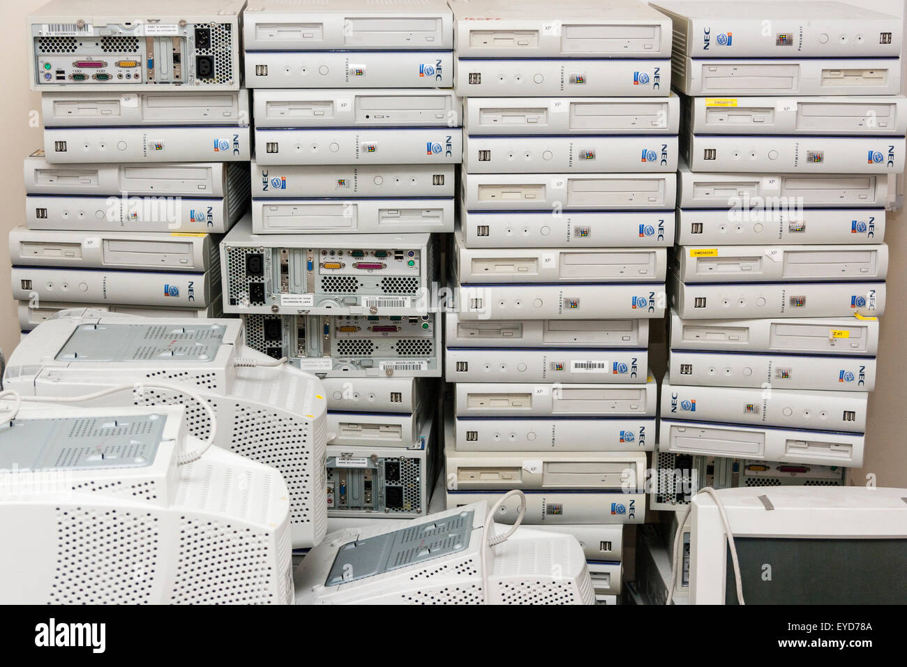 Junked computers stored in room. Piles of stacked white computer bases ...