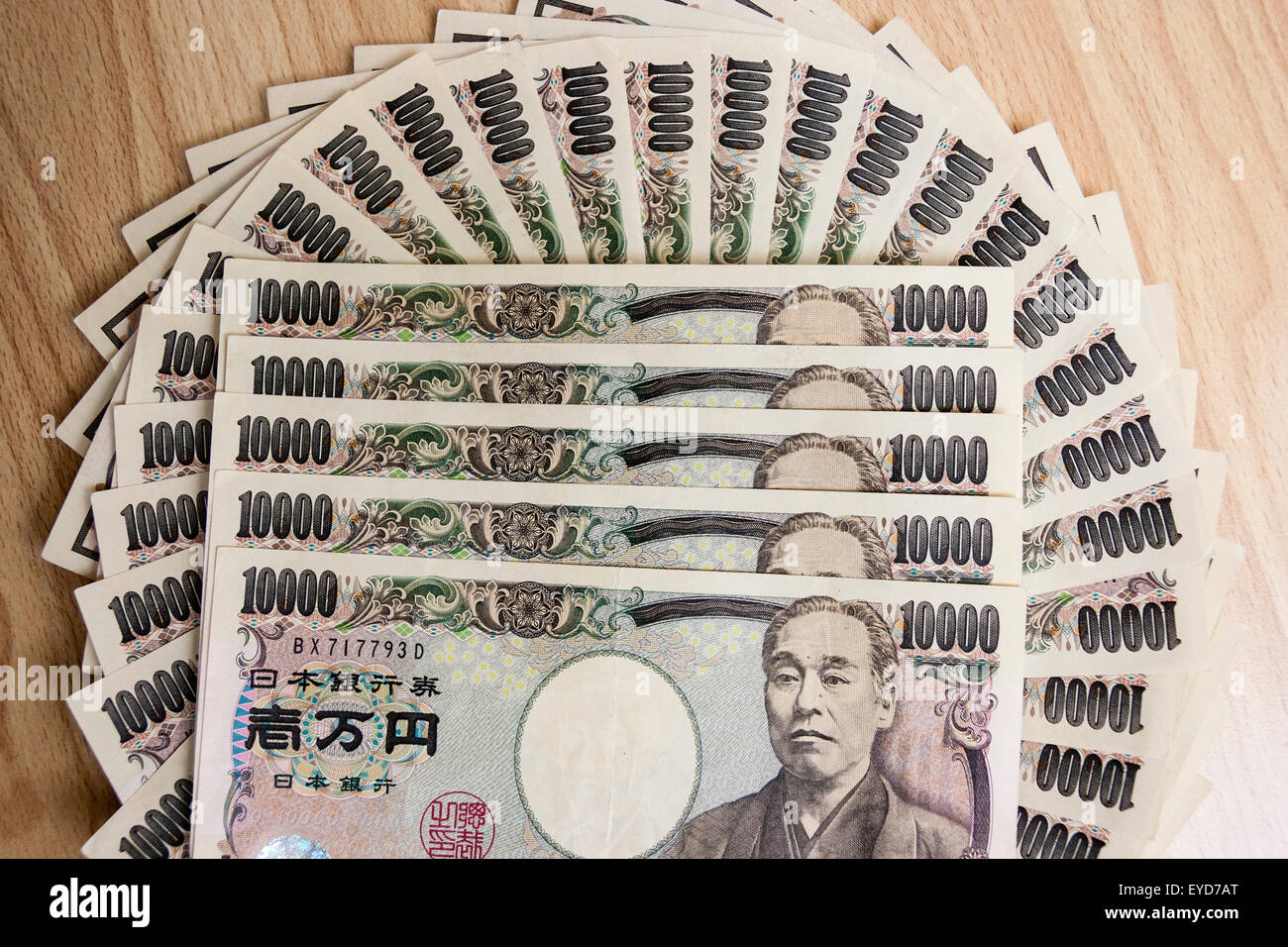 Japanese money, 10,000 yen banknotes, spread in round pattern on wood ...