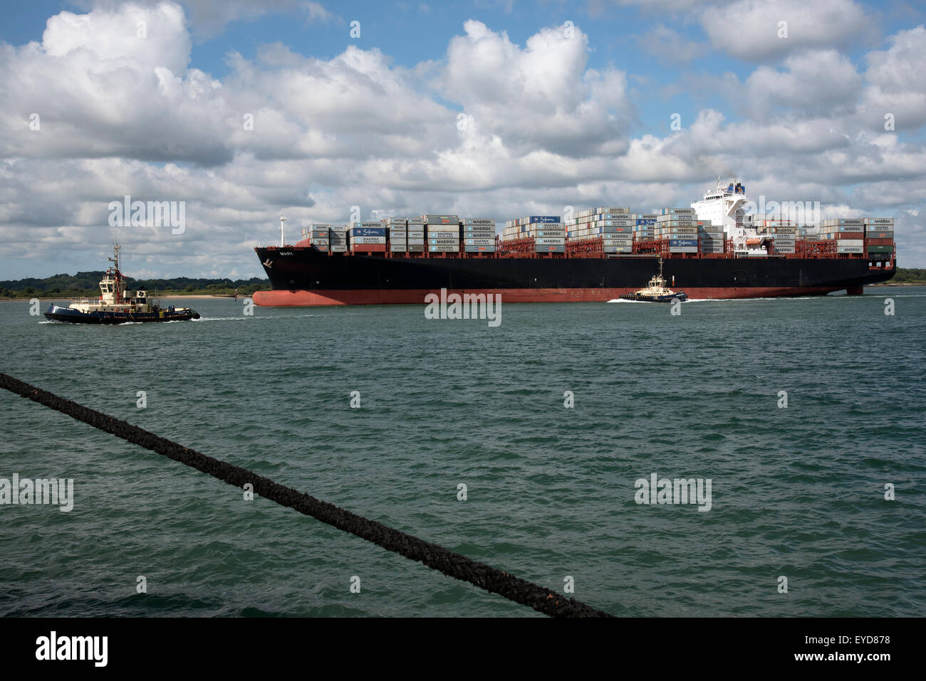 Container carrier ship with tugboat support on Southampton Water ...