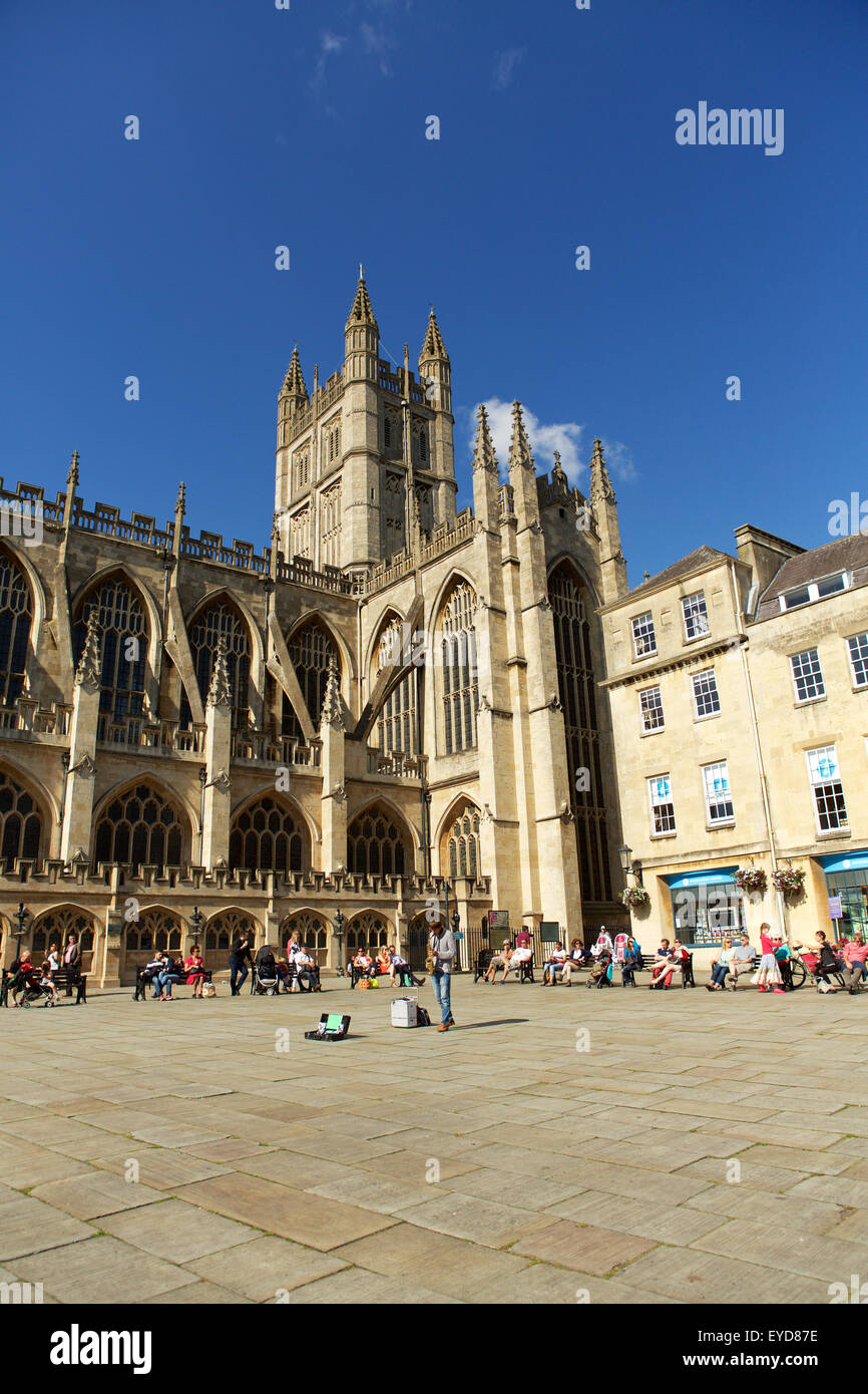 Busker playing the Saxophone in the square with Bath Abbey in the ...