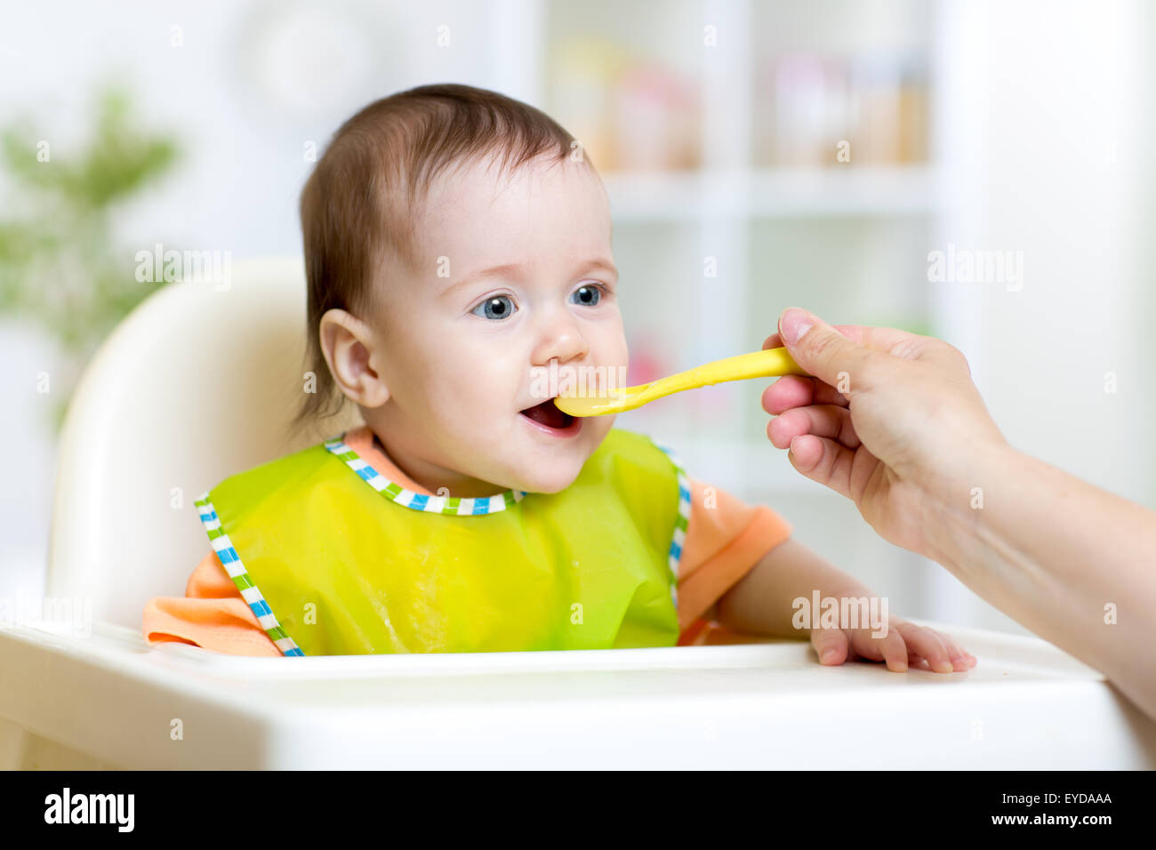 Pretty kid eating with spoon Stock Photo - Alamy