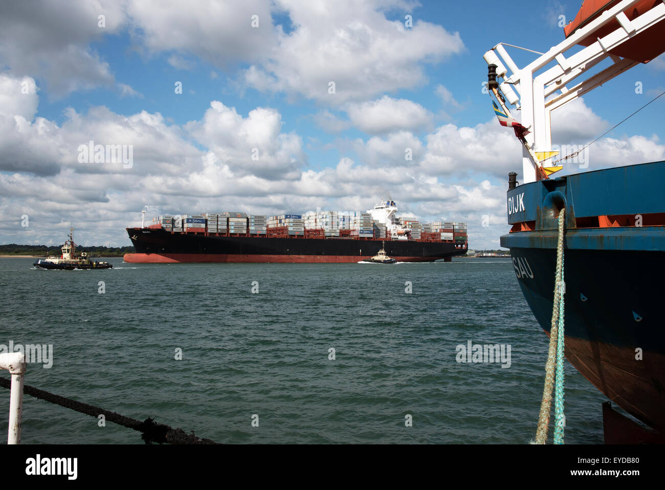 Container carrier ship with tugboat support on Southampton Water ...