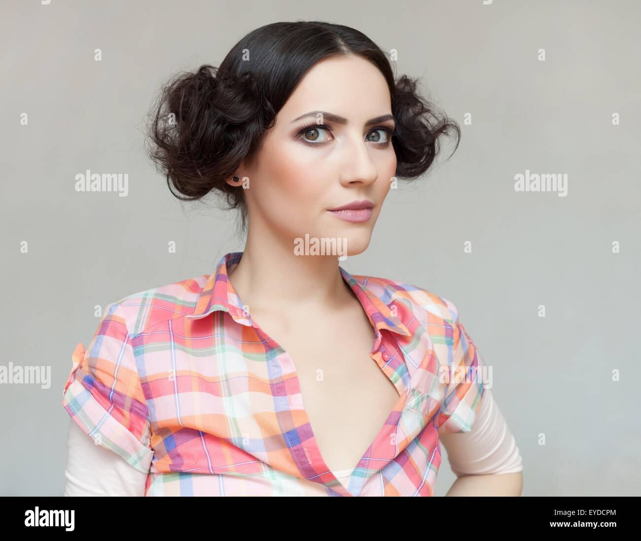 Beautiful sporty woman with two loops of hair dressed in a casual shirt ...