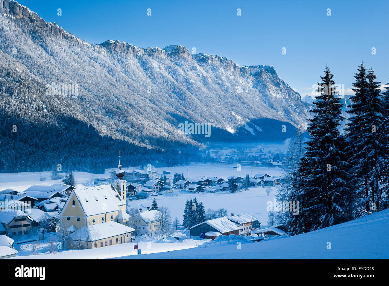 Snow Covered Village With Mountains And Picturesque Church In A Valley ...
