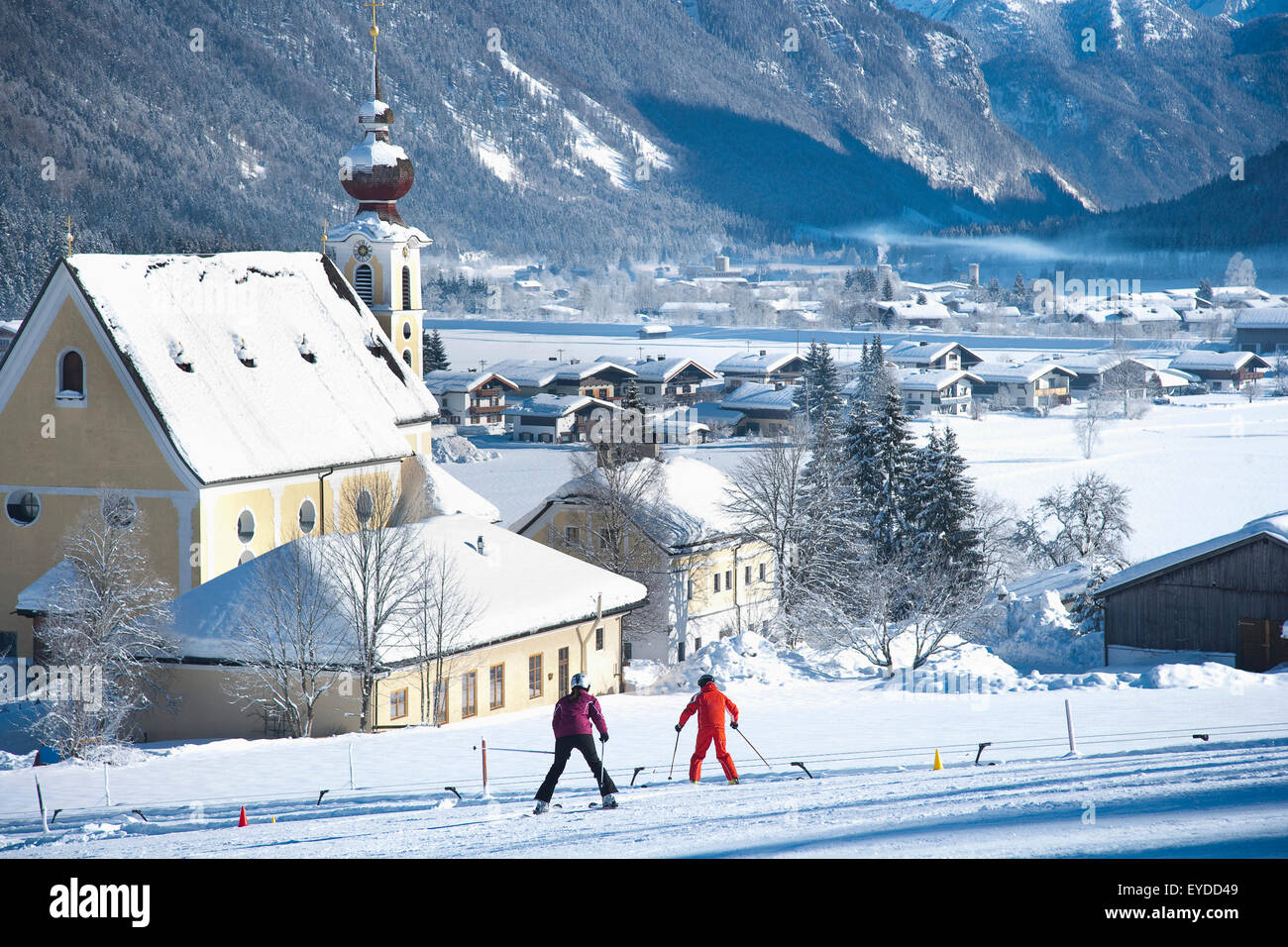 Snow Covered Village With Mountains And Picturesque Church In A Valley ...