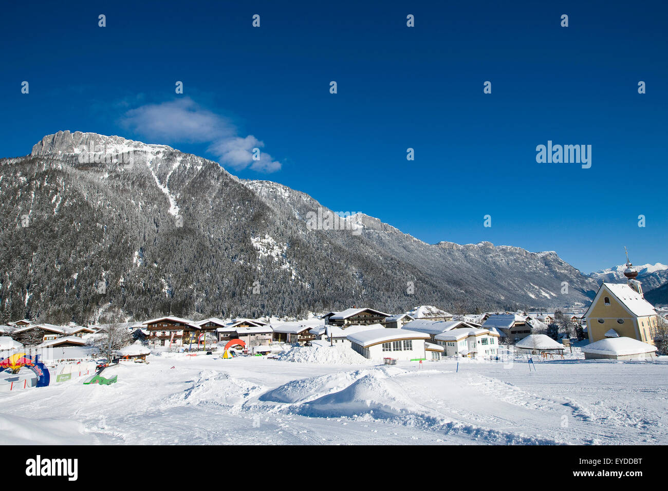 Snow Covered Village With Mountains And Picturesque Church In A Valley ...