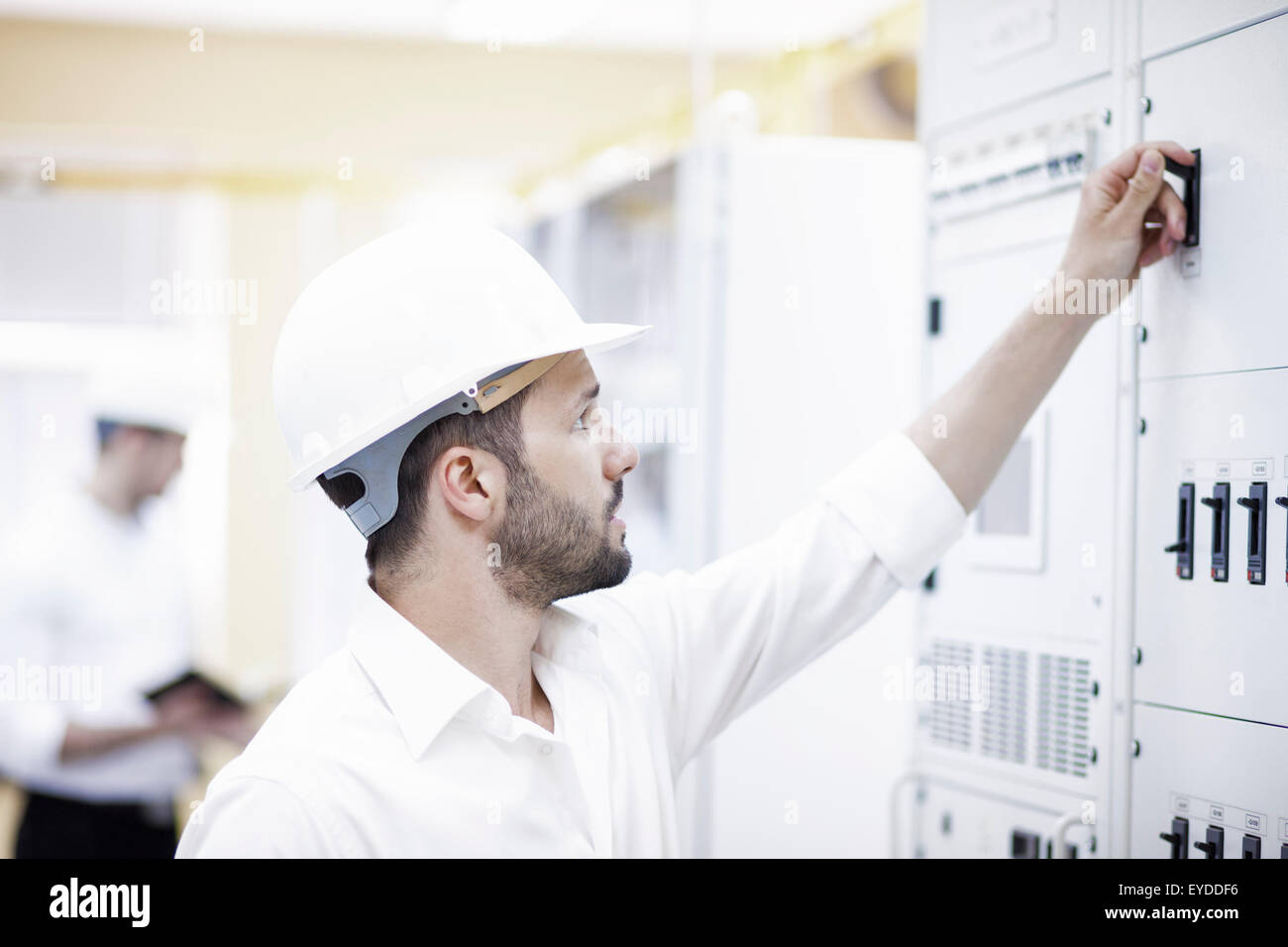 Two engineers checking switch in electricity substation Stock Photo - Alamy