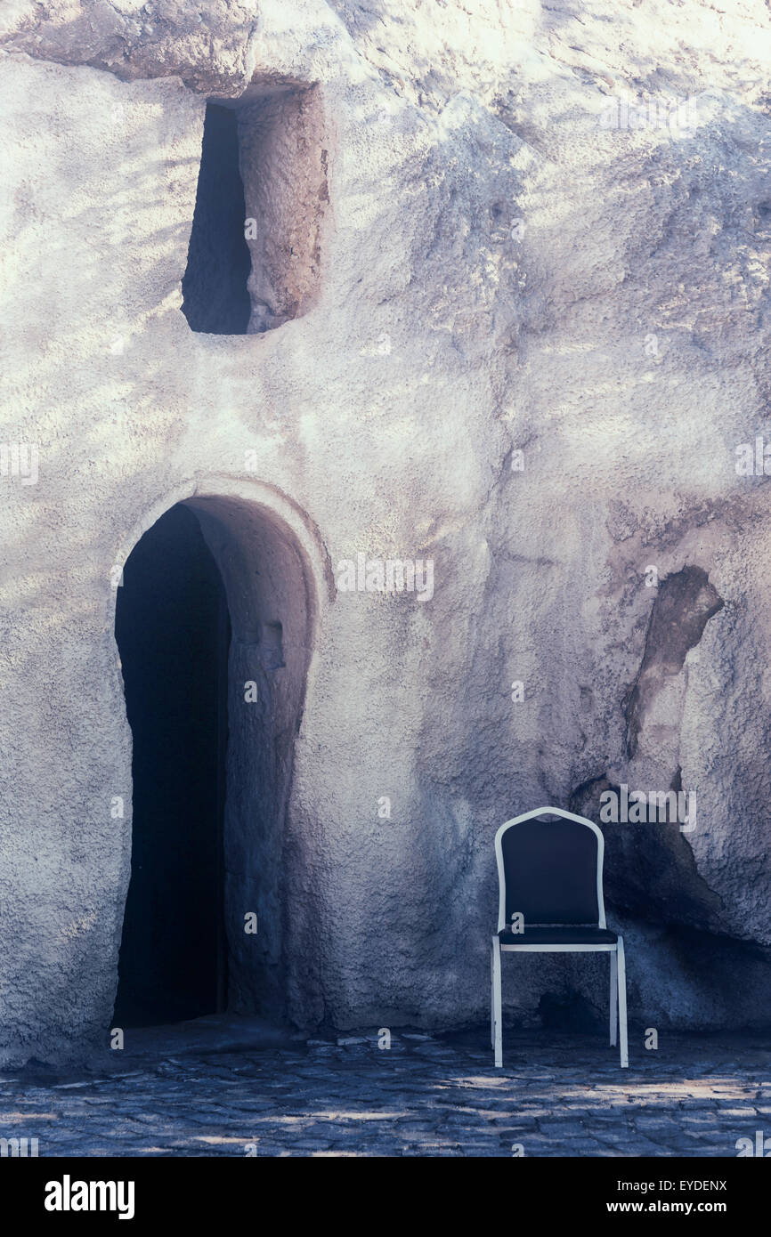 an ancient cave house with a chair in front of the door Stock Photo - Alamy