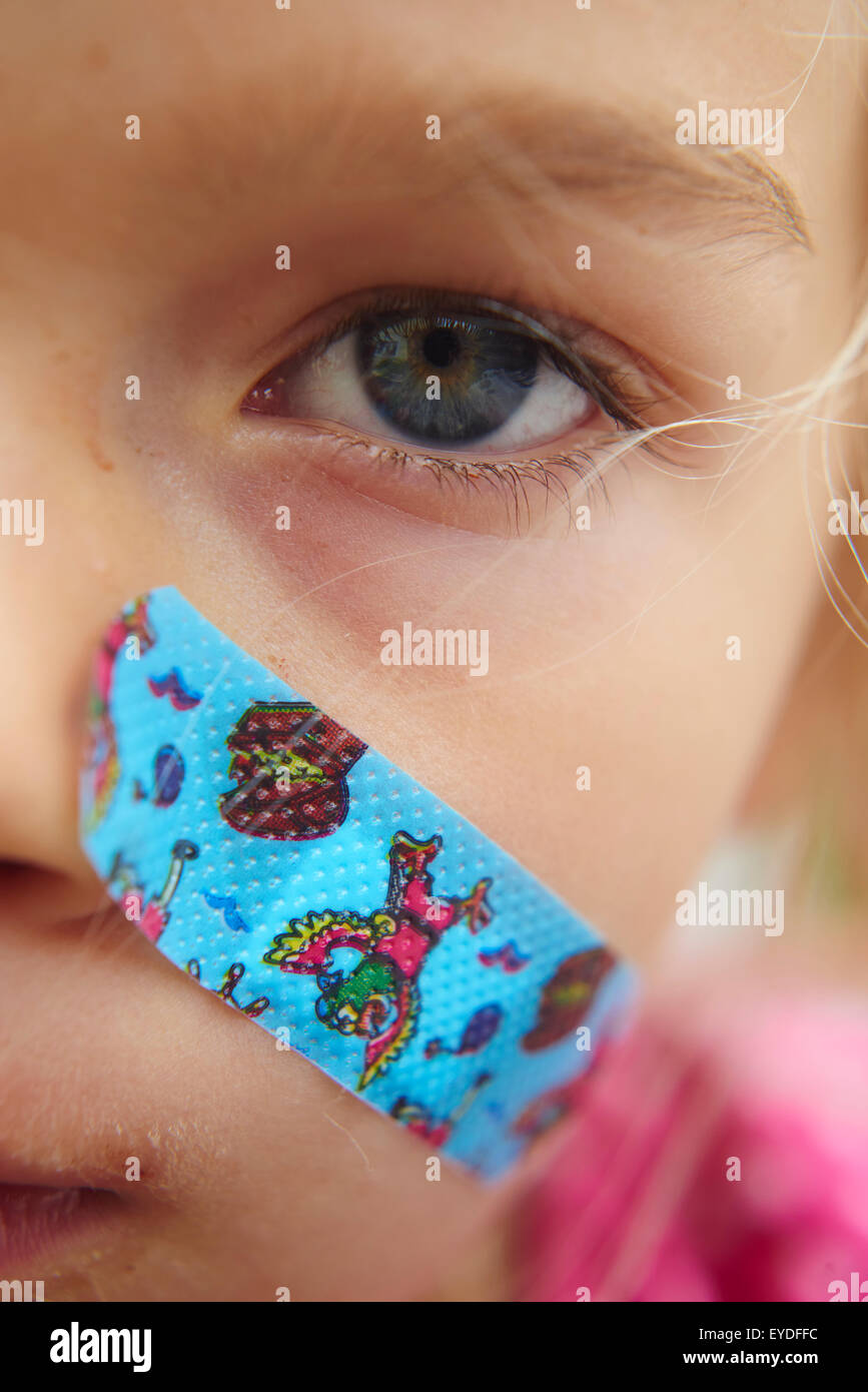 Close up of injured child Girl with plaster on her cheek Stock Photo ...