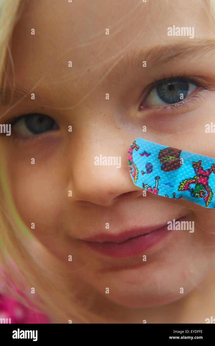 Close up of injured child Girl with plaster on her cheek Stock Photo ...