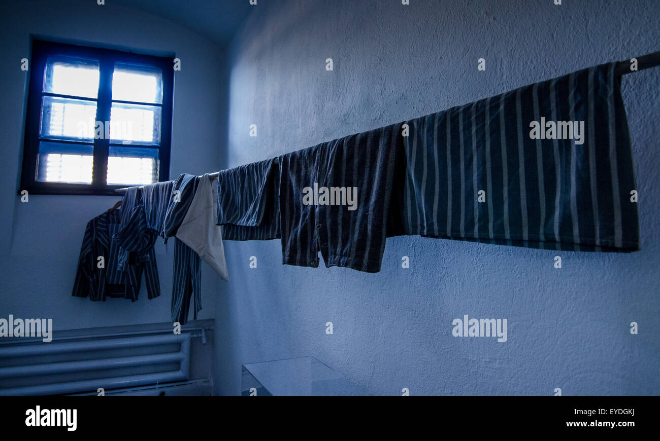 Inside a historic prison cell with basic furnishings and a small window ...