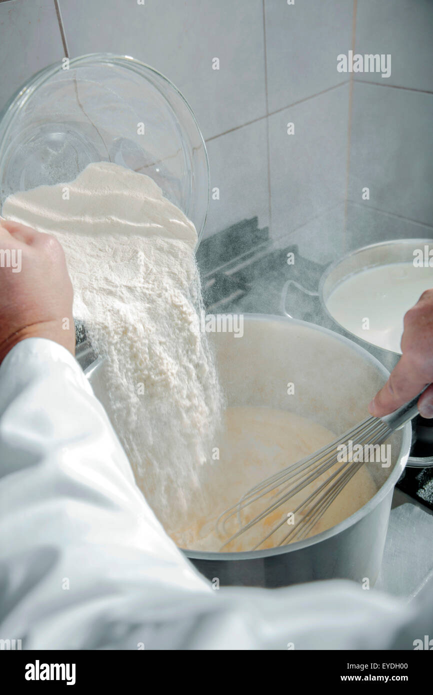 Adding flour into metal bowl Stock Photo - Alamy