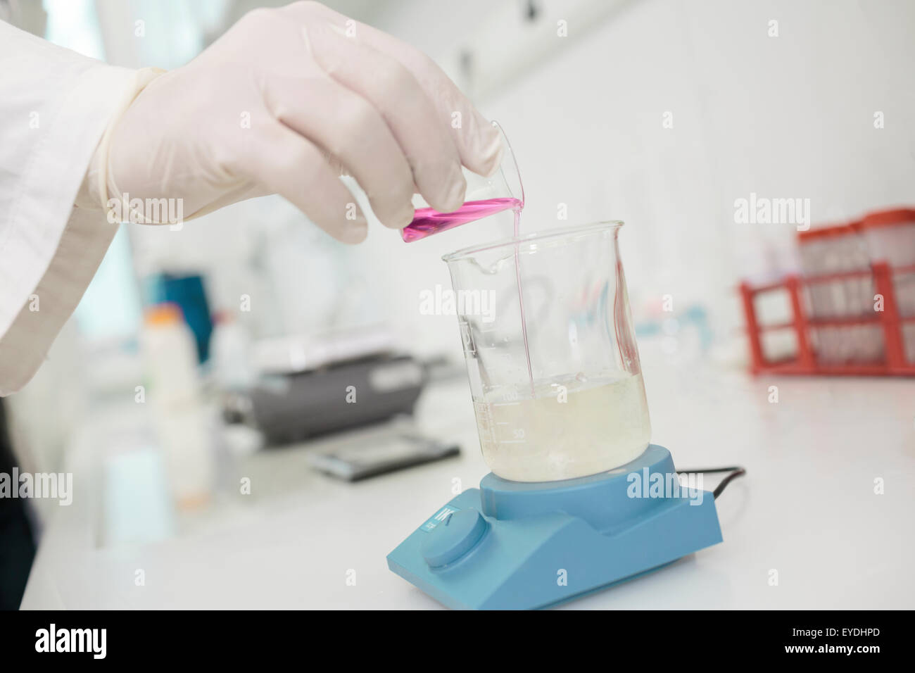 Scientist pouring liquid into beaker in laboratory Stock Photo - Alamy