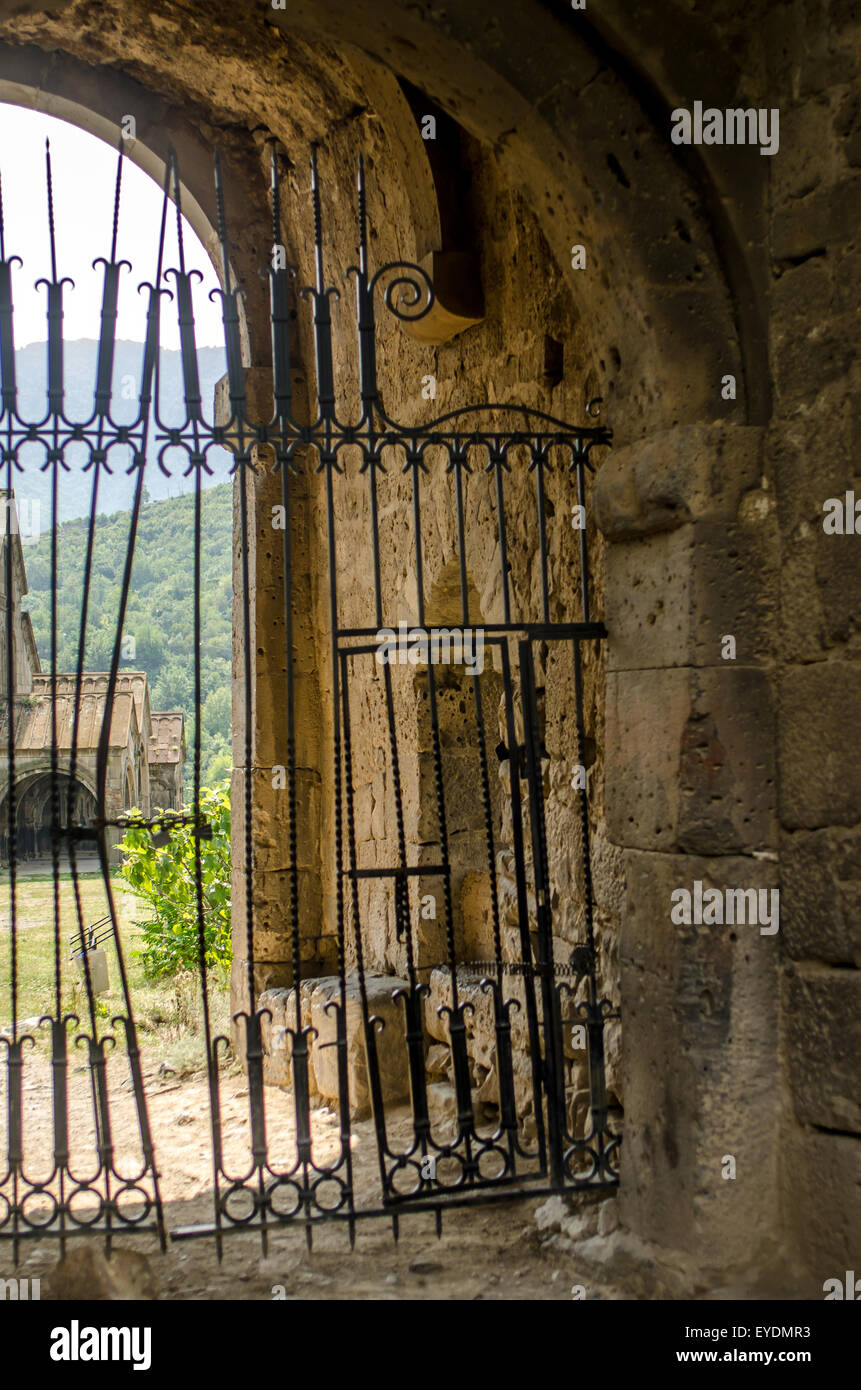 Rusty gate leading to ancient stone architecture in a mountainous ...