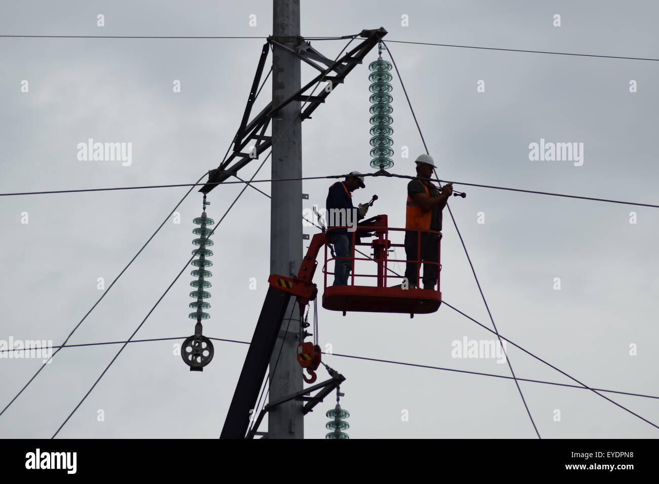 Electrician lineman repairman worker at climbing work on electric post ...