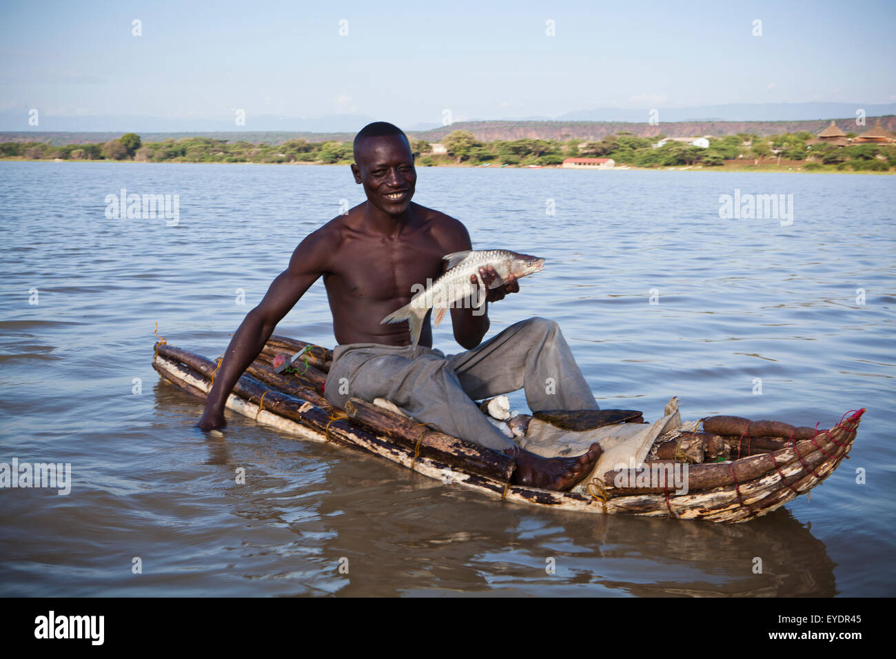 Kenya, Rift Valley, Fisherman showing fish in small canoe; Lake Baringo ...