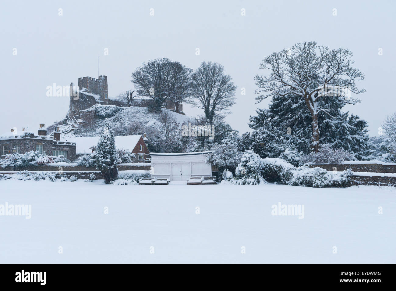 UK, East Sussex, Looking across bowling green to castle covered in snow ...