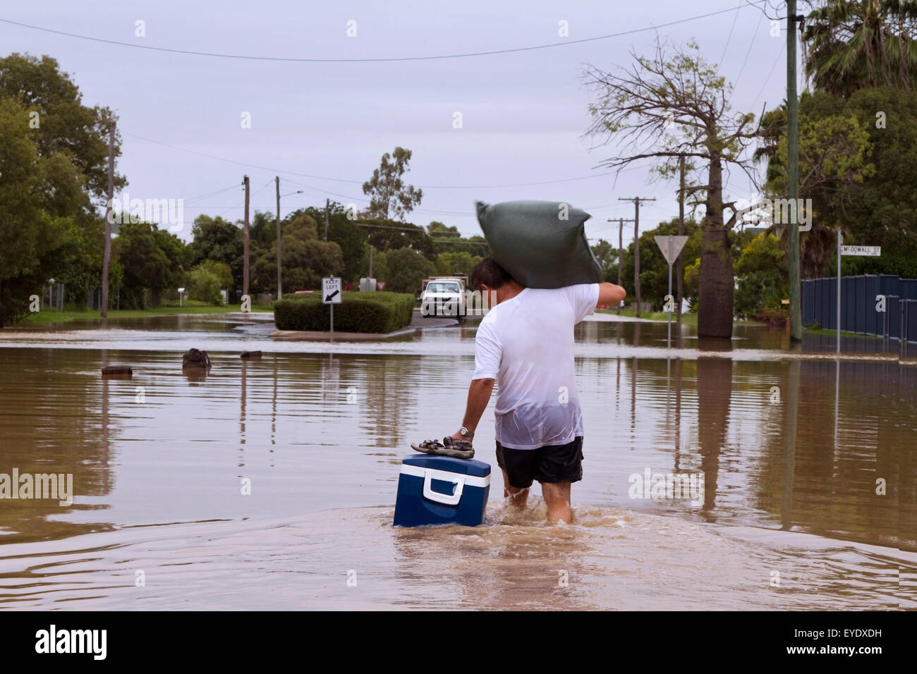 Man leaving his home during a flood taking his possessions with him ...