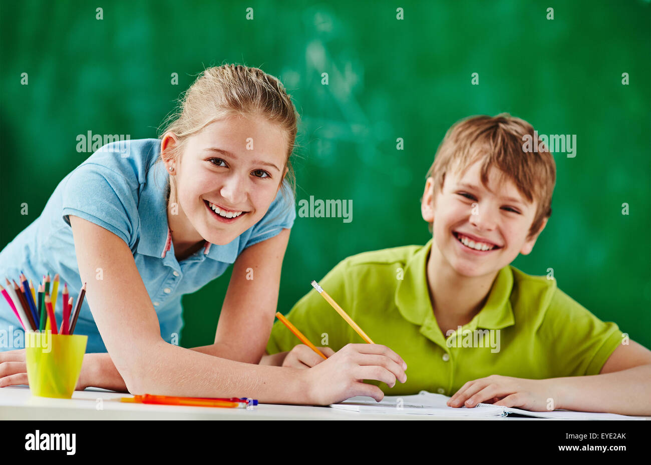Happy classmates drawing and looking at camera Stock Photo - Alamy