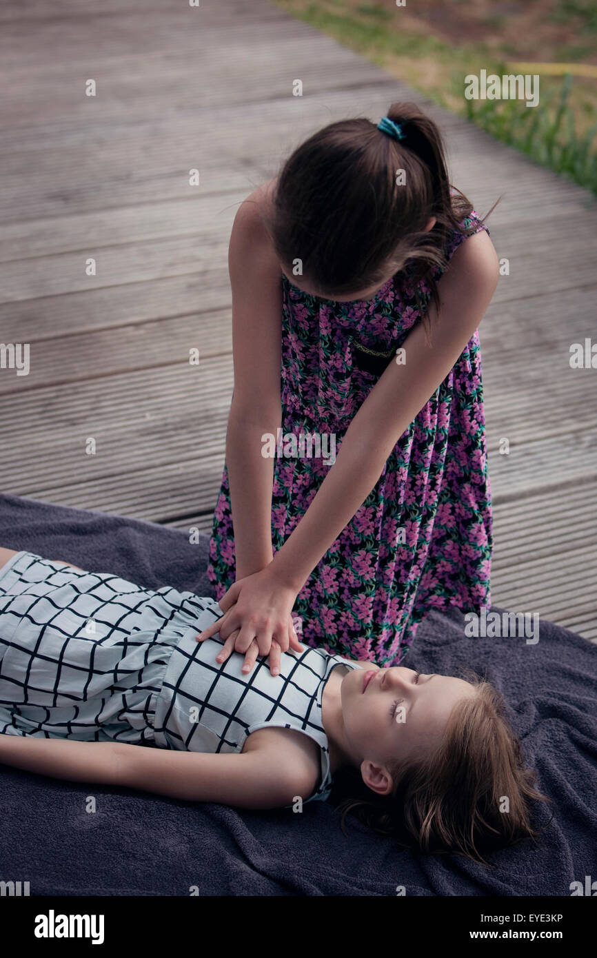 Child practising first aid CPR on another child Stock Photo - Alamy