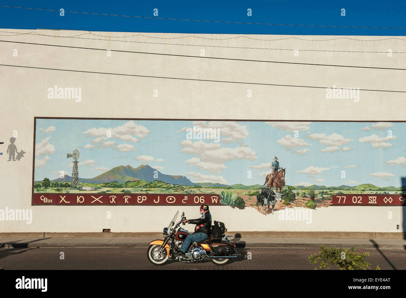Motorcyclist Riding A Harley Davidson Passing A Cowboy Rancher Mural ...