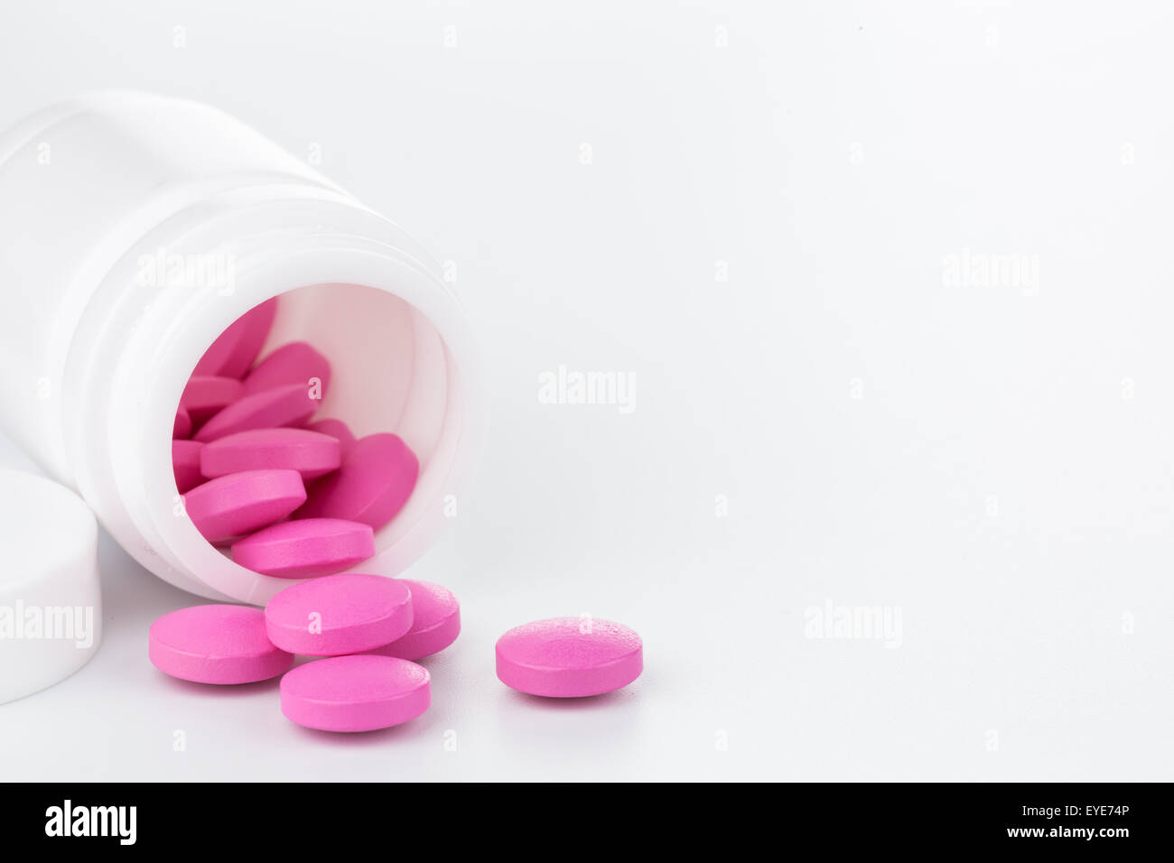 pink pills an pill bottle on white background (Isolated Stock Photo - Alamy