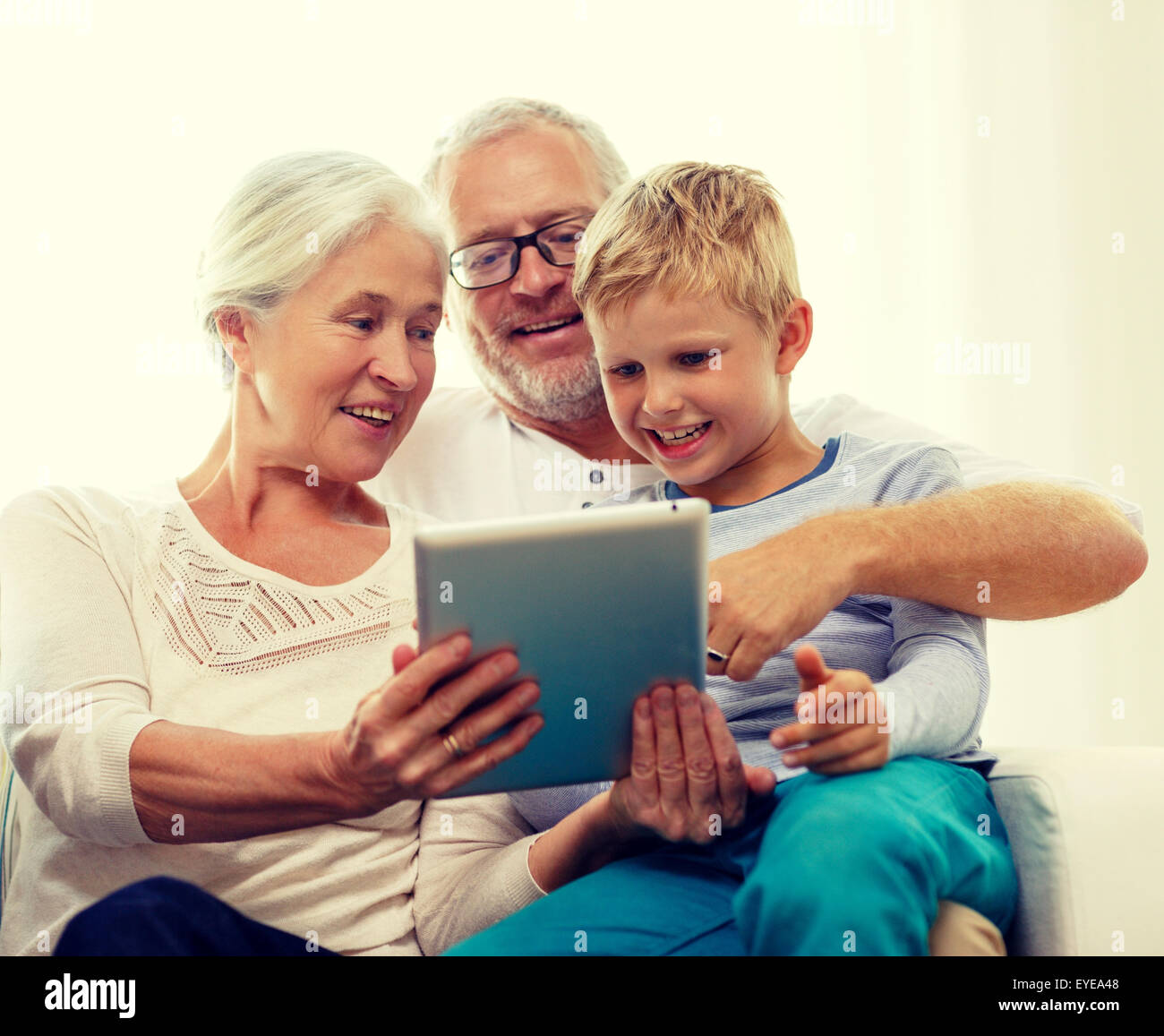 smiling family with tablet pc at home Stock Photo - Alamy