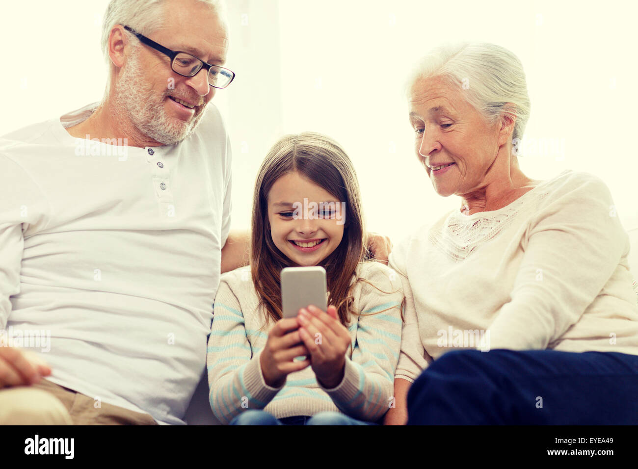 smiling family with smartphone at home Stock Photo - Alamy