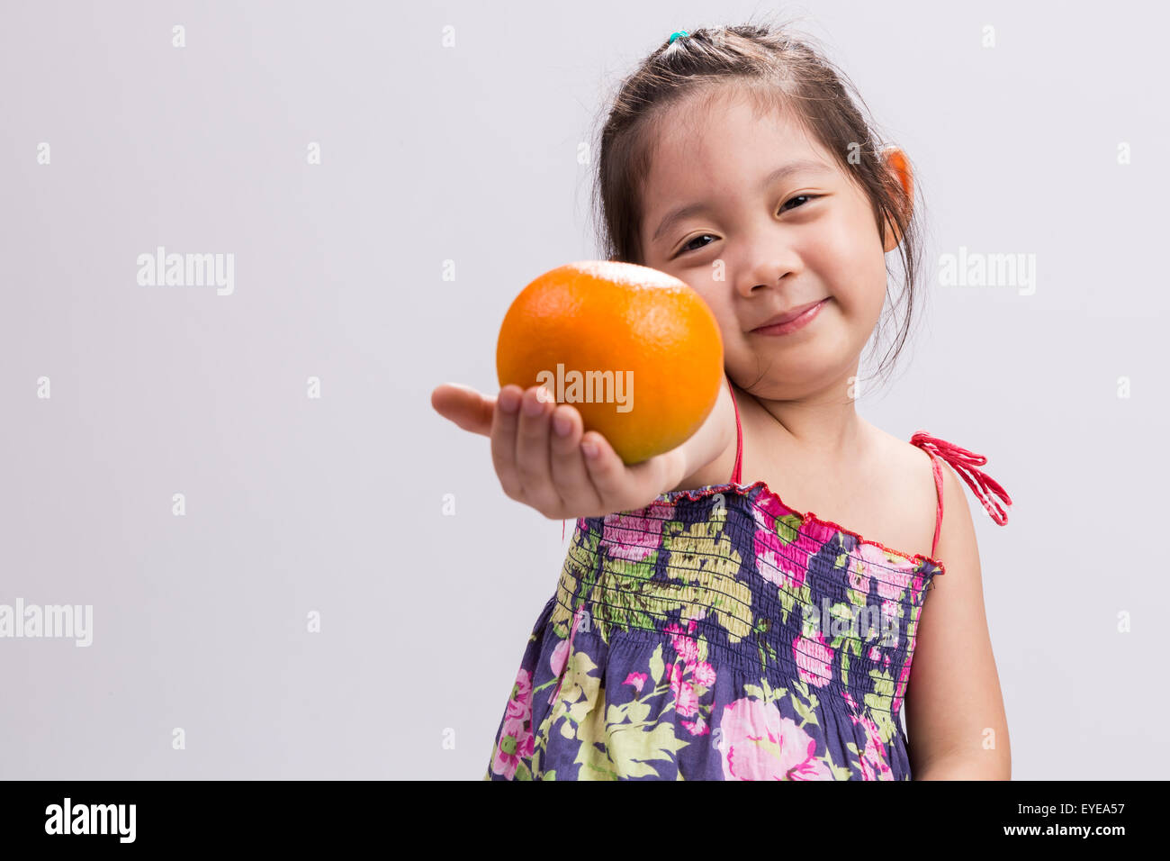 Child is holding orange in her hand background Stock Photo - Alamy