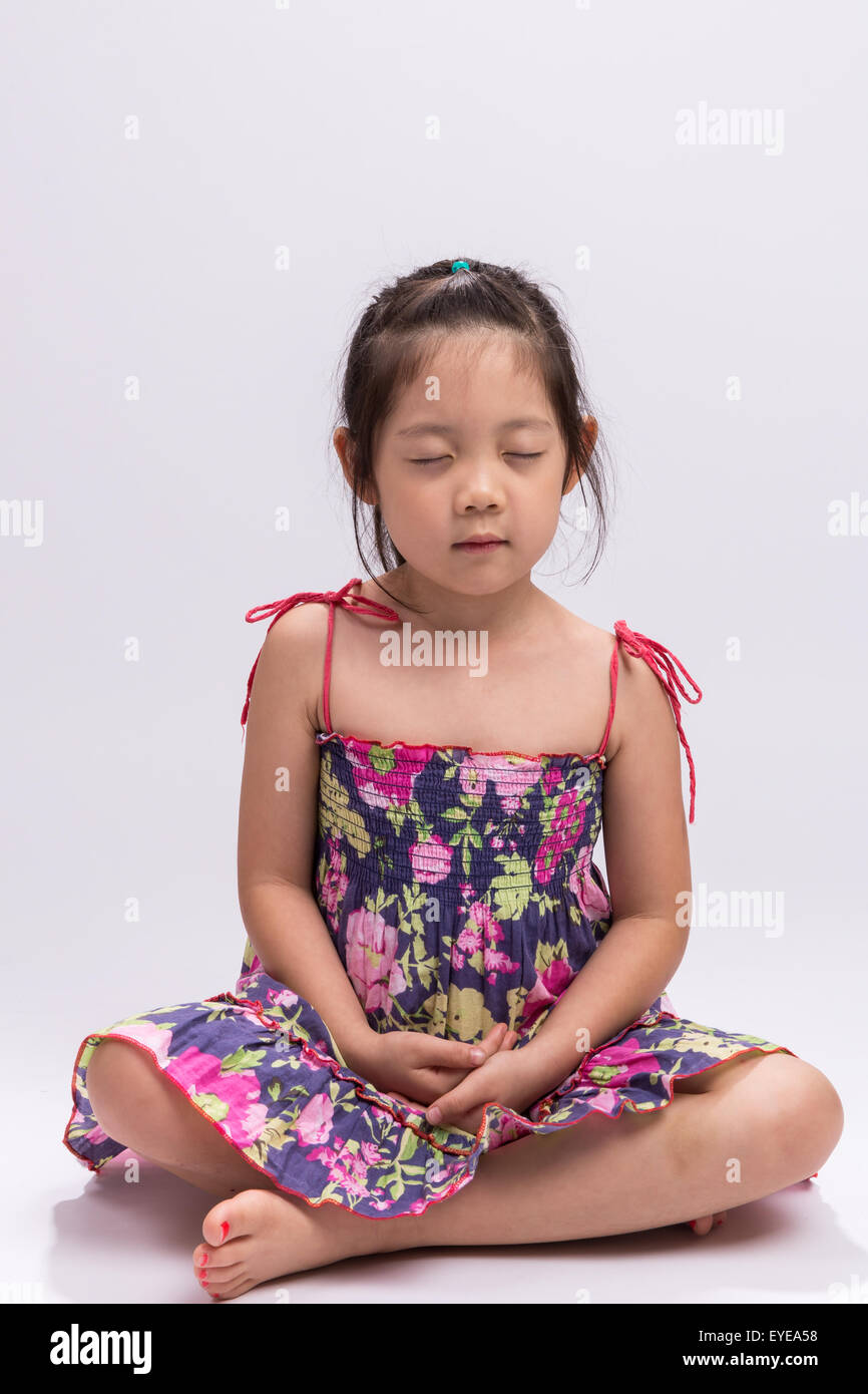 Little girl does mediation alone on with white background Stock Photo ...