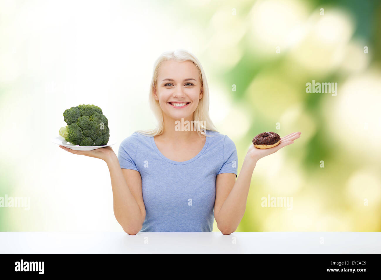 Woman holding donut and salad hi-res stock photography and images - Alamy