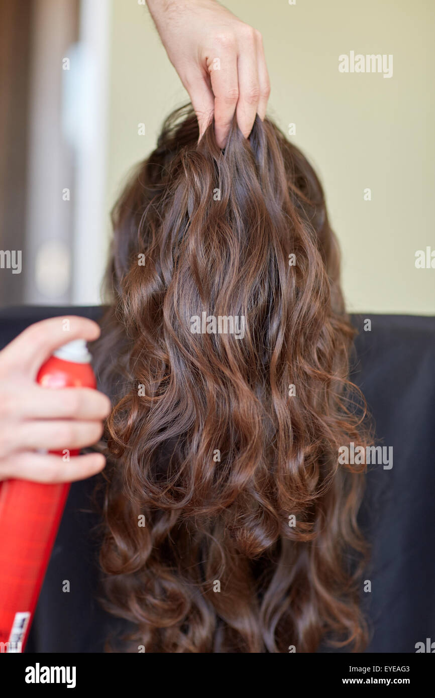 stylist with hair spray making hairdo at salon Stock Photo - Alamy