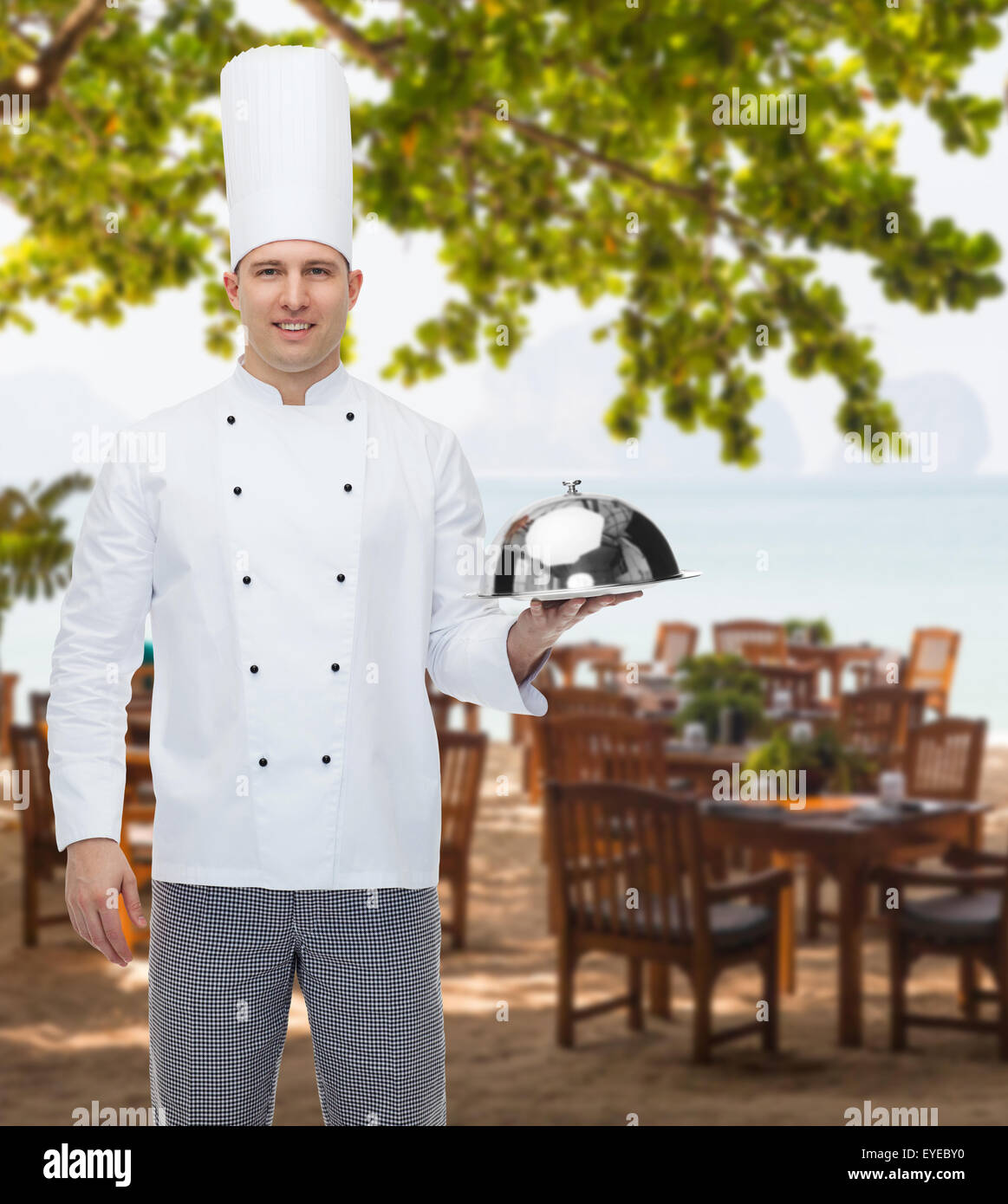 happy male chef cook holding cloche Stock Photo - Alamy