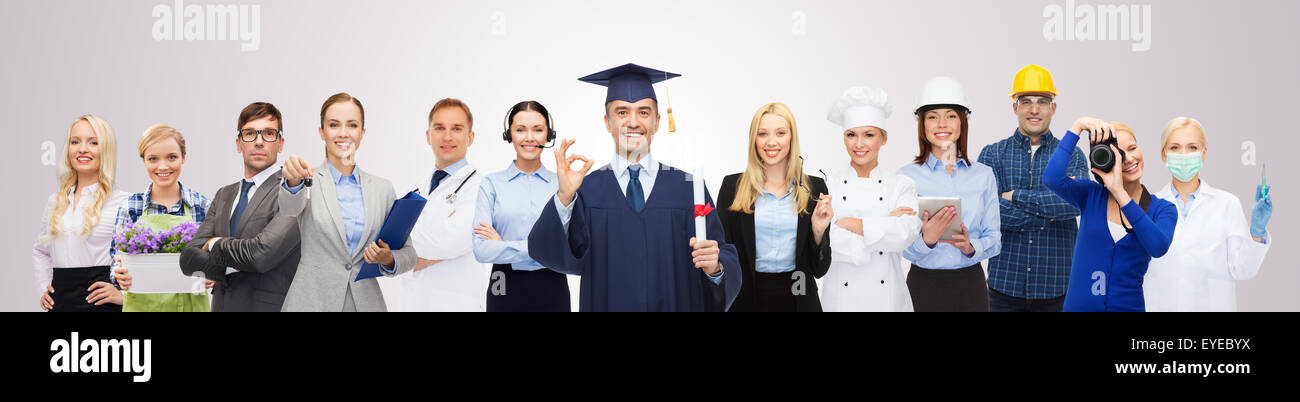 happy bachelor with diploma over professionals Stock Photo - Alamy