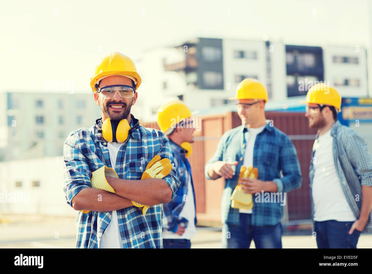 group of smiling builders in hardhats outdoors Stock Photo - Alamy